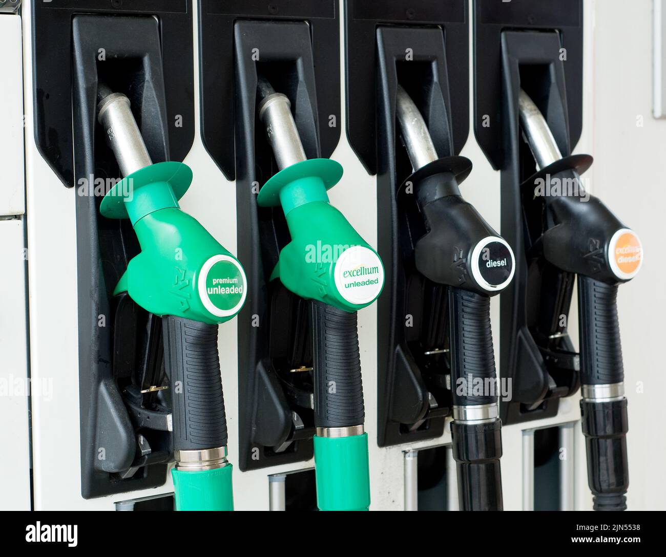 View of four petrol and diesel fuel nozzles in position on the pump dispenser at a refueling ...