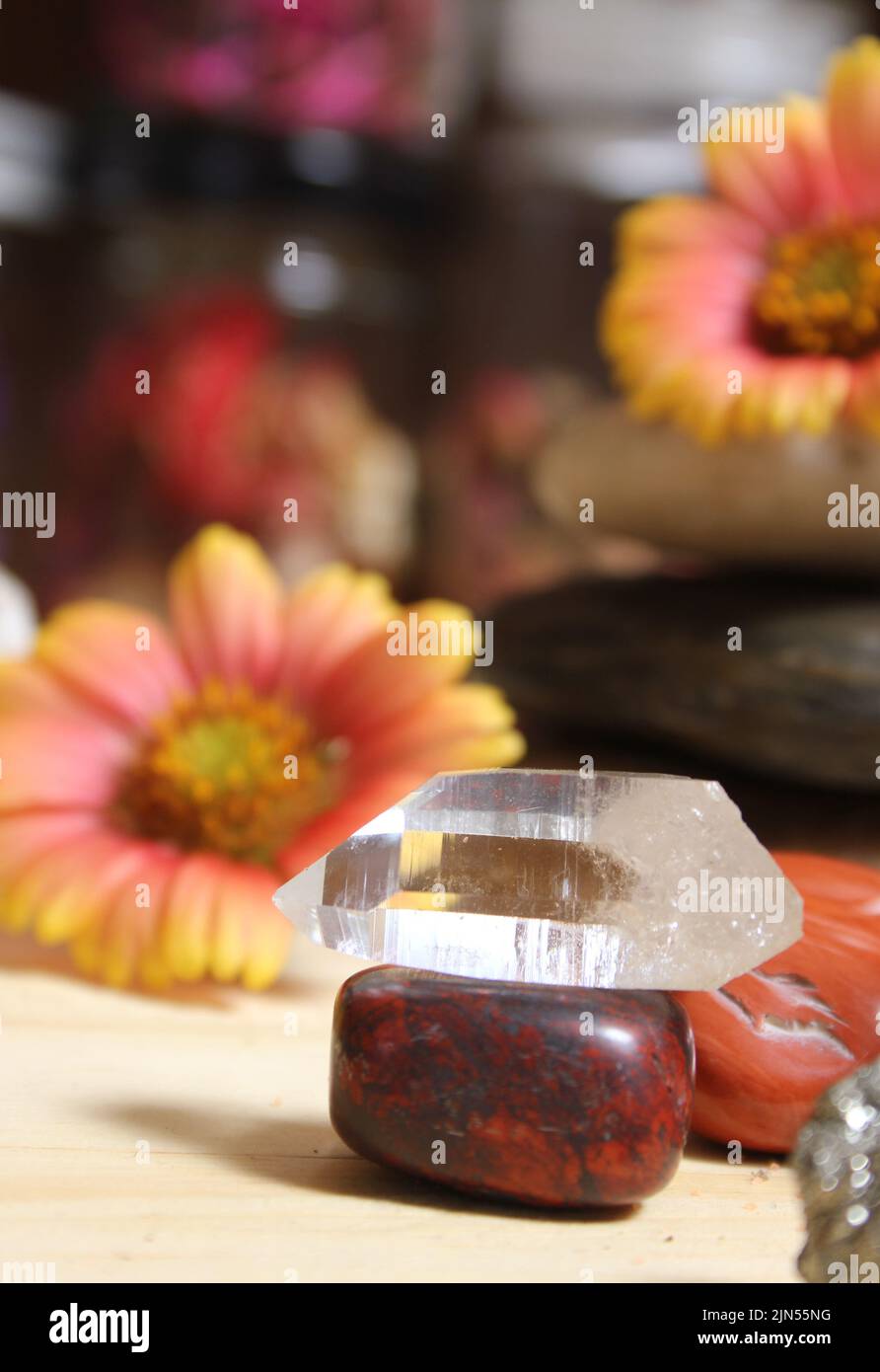 Quartz Crystal Balanced on Bloodstone With Flowers in Background Stock ...