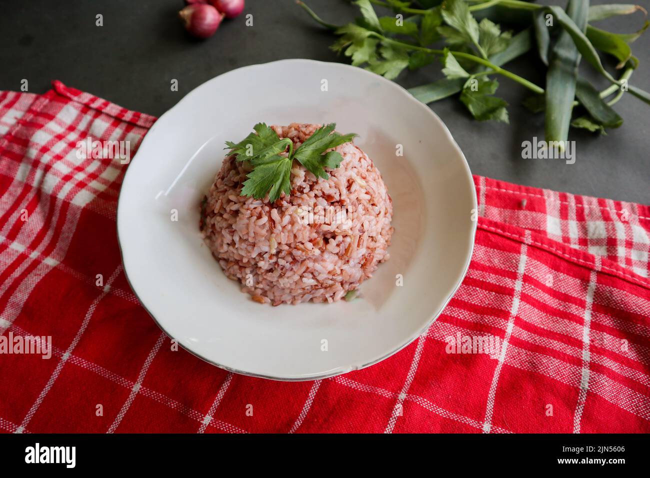 Red steamed rice or nasi merah served in plate isolated on black ...