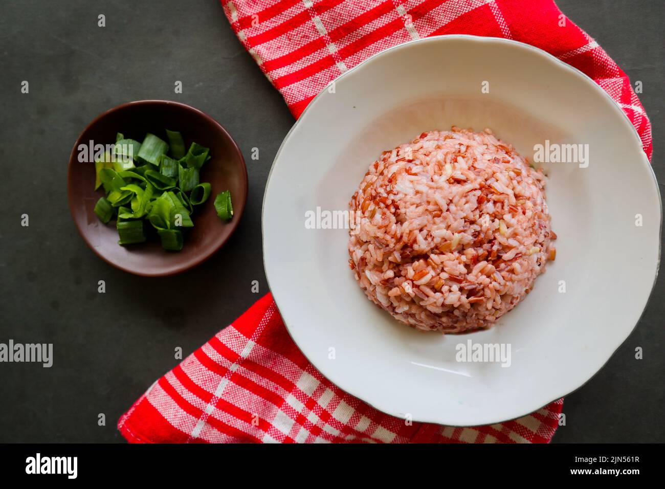 Red steamed rice or nasi merah served in plate isolated on black ...