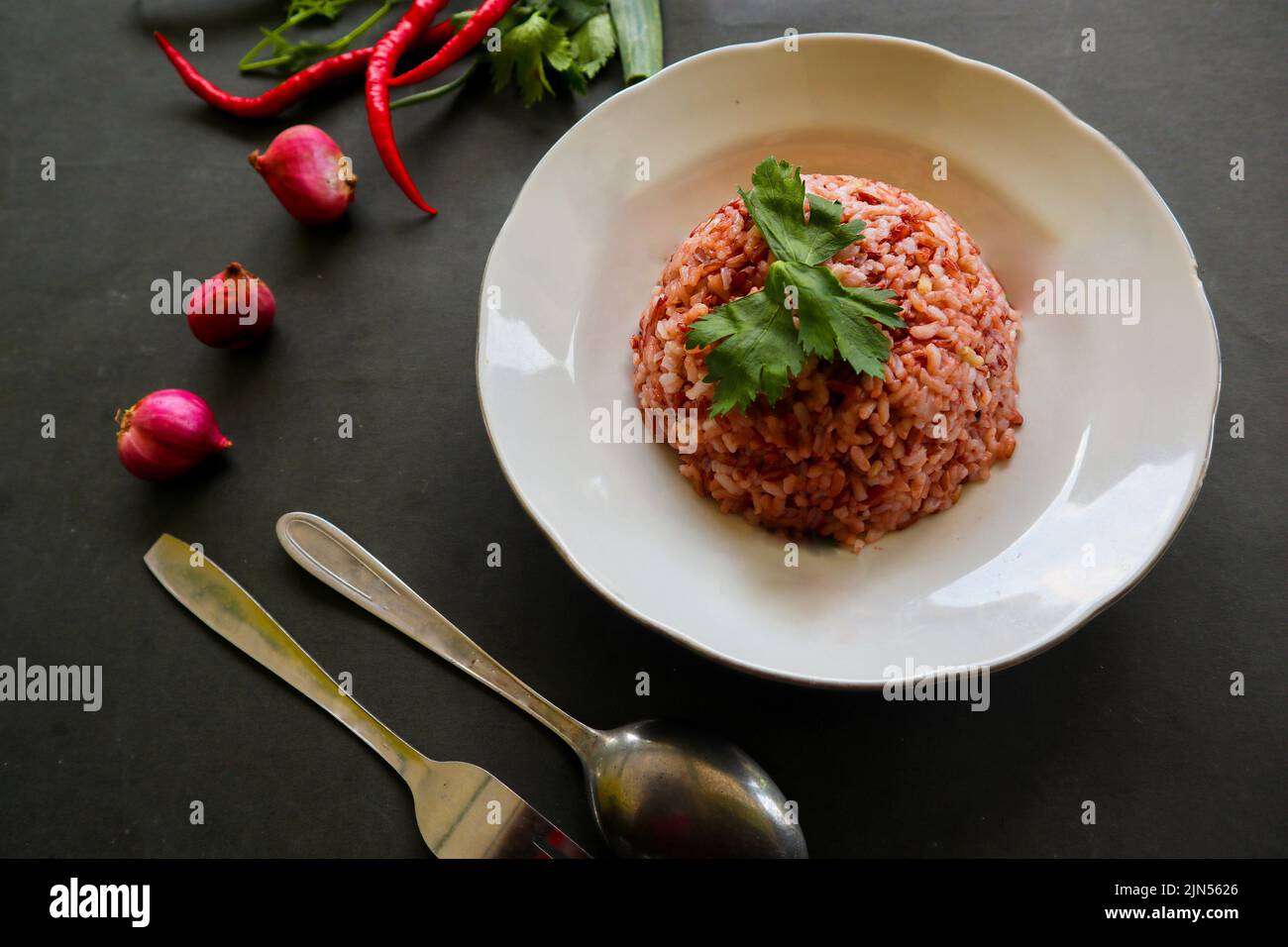 Red steamed rice or nasi merah served in plate isolated on black ...