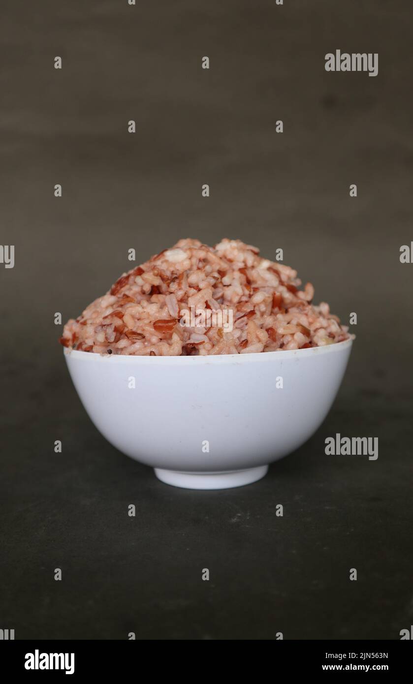 Red steamed rice or nasi merah served in plate isolated on black ...