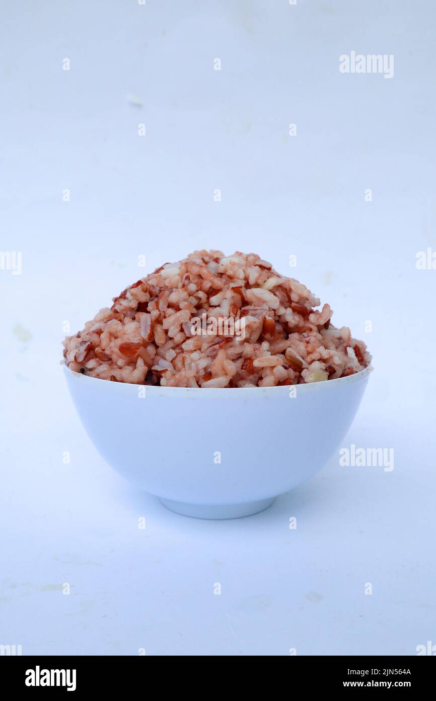 Red steamed rice or nasi merah served in plate isolated on black ...