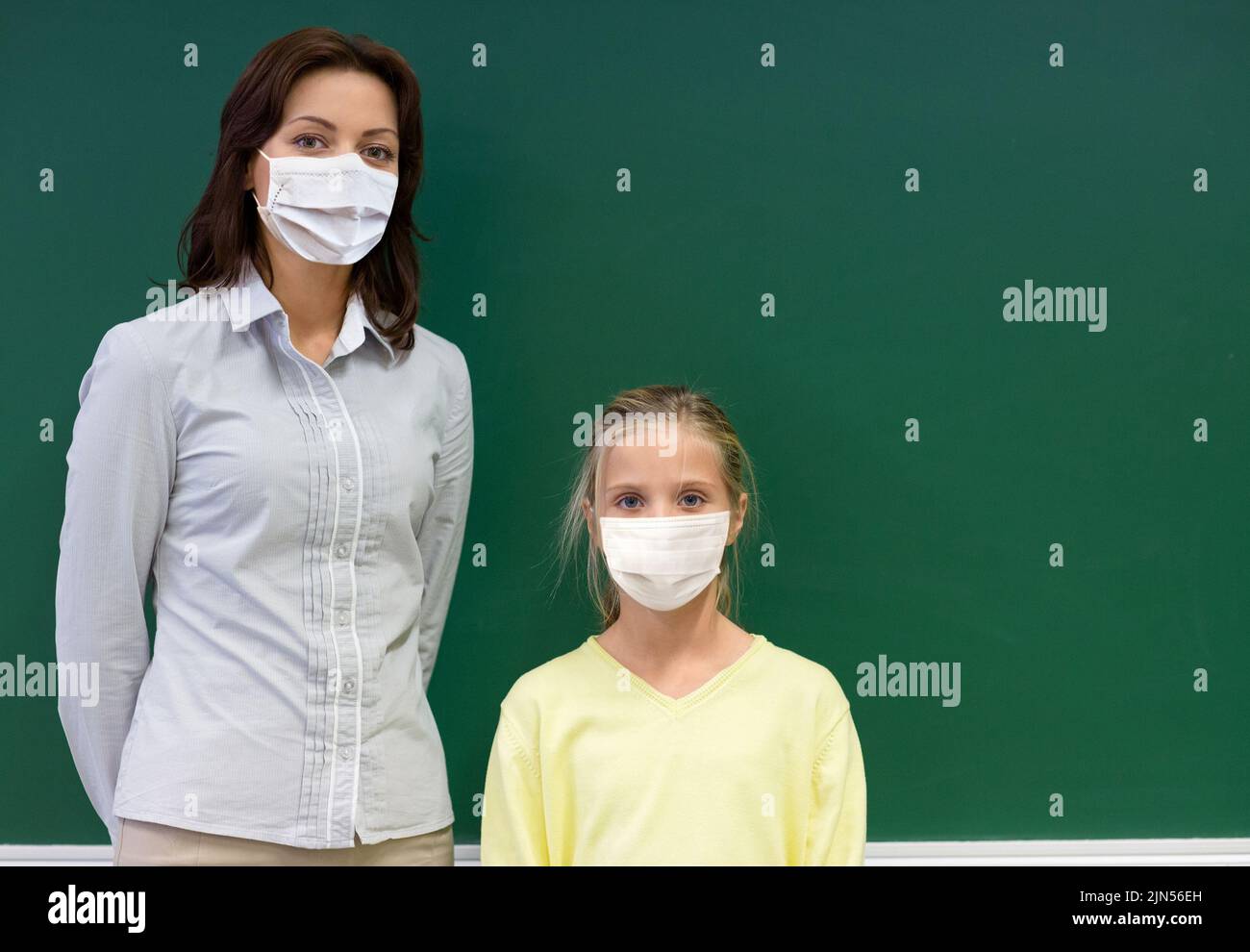 student girl and teacher in masks at school Stock Photo - Alamy