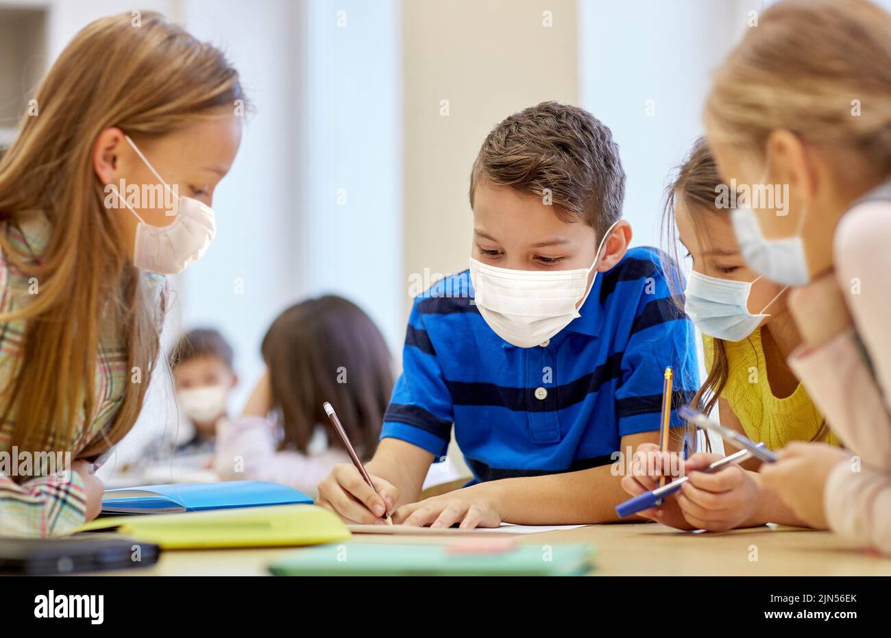 group of students in masks learning at school Stock Photo - Alamy