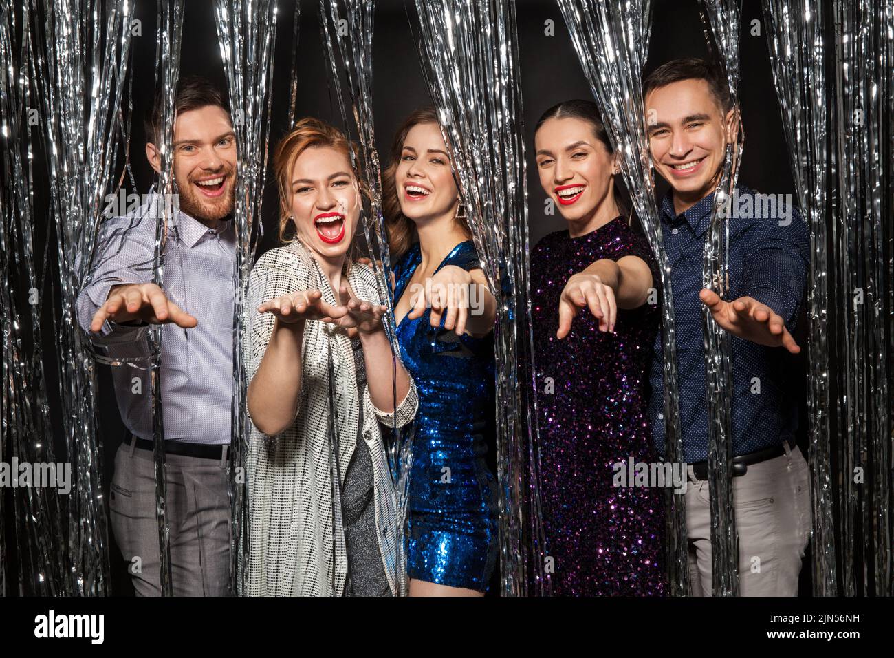 happy friends in party clothes with tinsel curtain Stock Photo - Alamy
