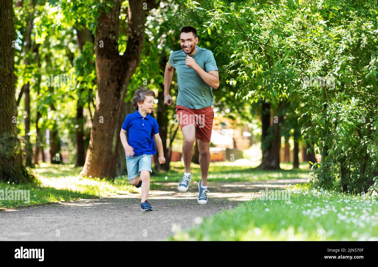 happy father and son compete in running at park Stock Photo - Alamy