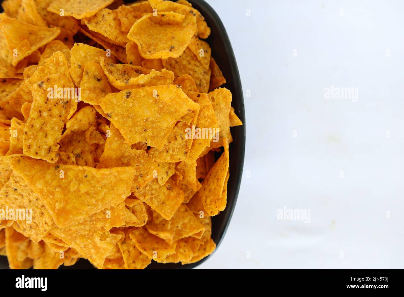 tortilla chip is corn chips or call nachos, served in bowl, on black ...