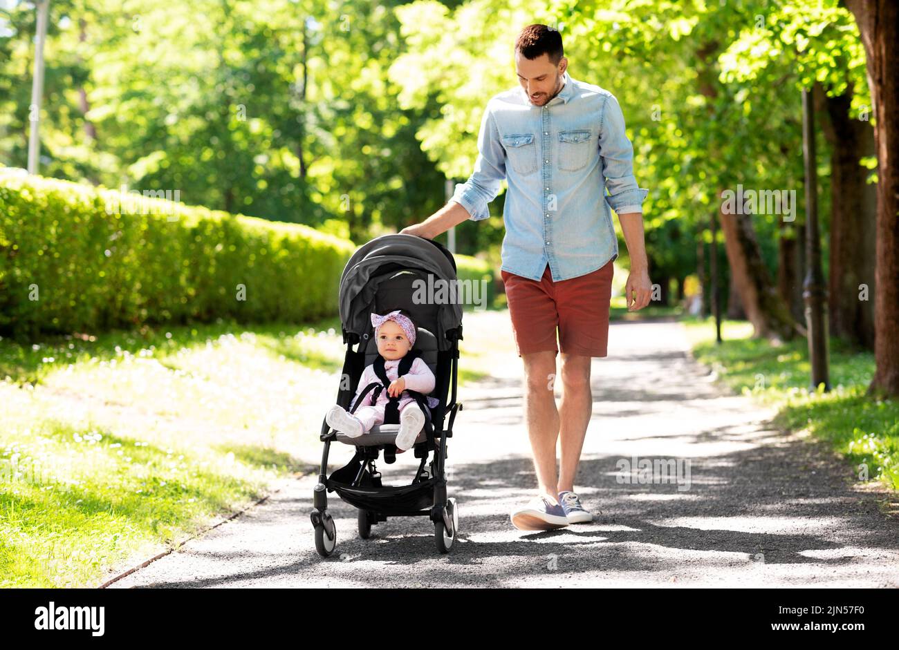 happy father with child in stroller at summer park Stock Photo - Alamy