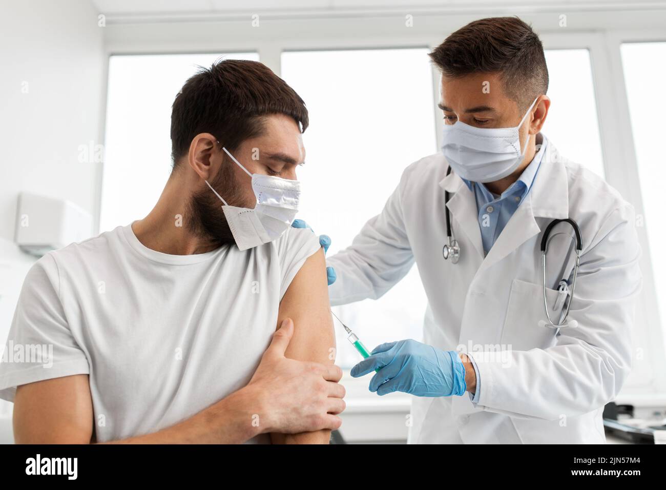 Doctor giving injection male patient hi-res stock photography and ...