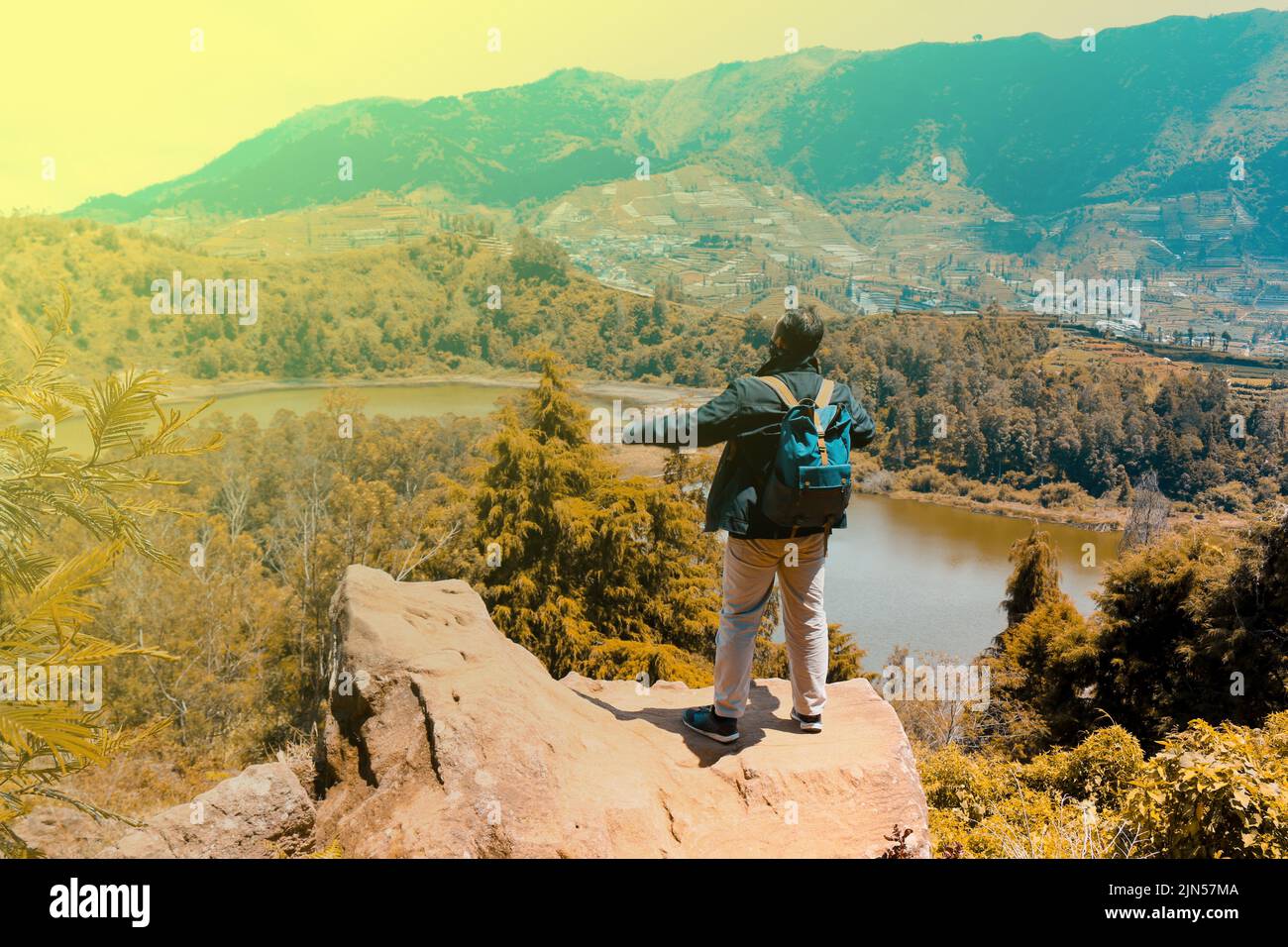 man standing on a rock of a cliff and enjoying the view of nature of ...