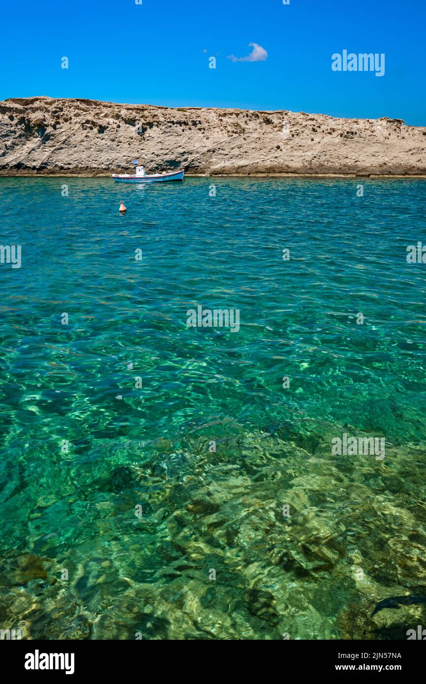 Anchored small fishing boat under Greek flag, azure sea waters, clear ...