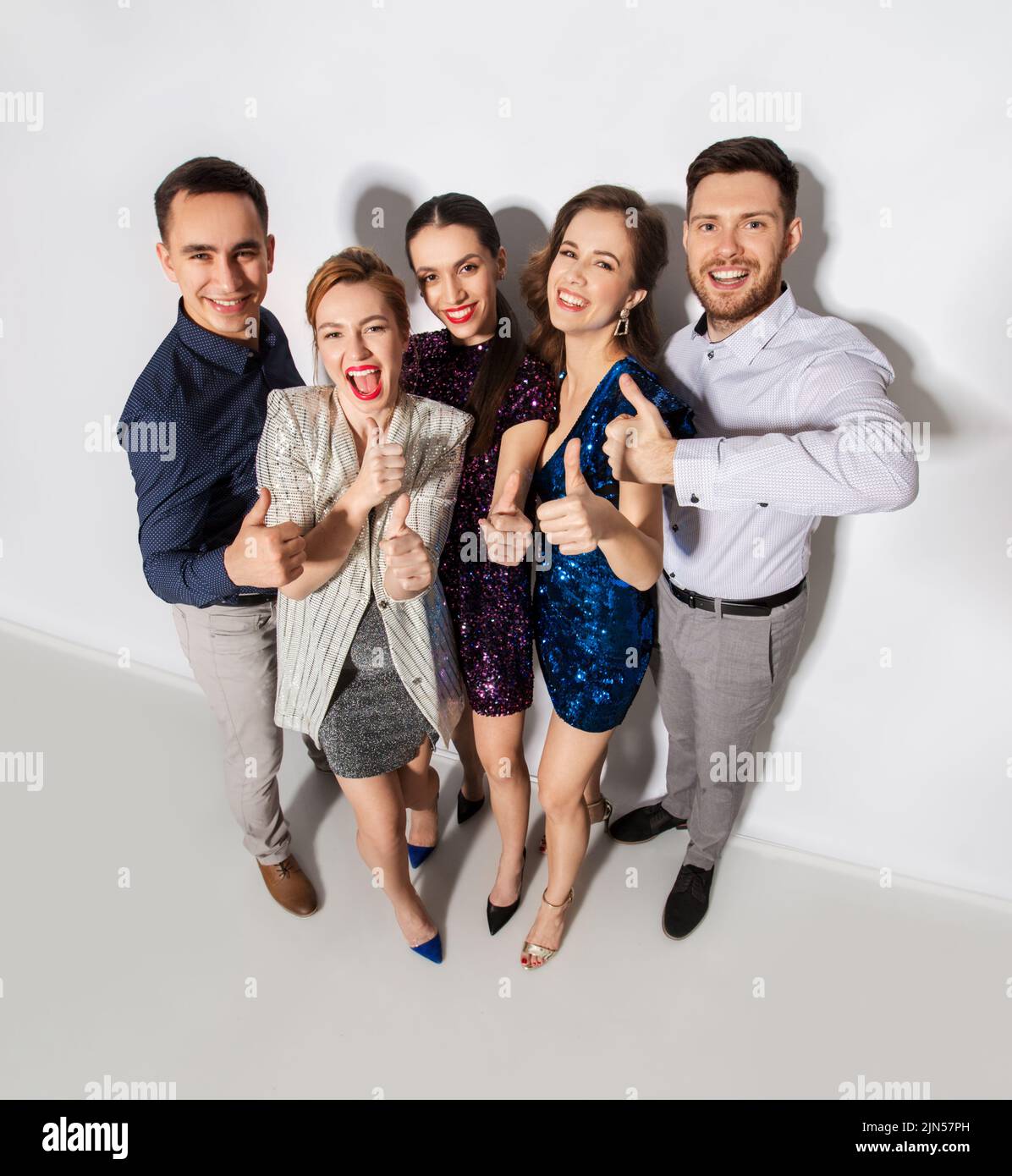 happy friends at party showing thumbs up Stock Photo - Alamy