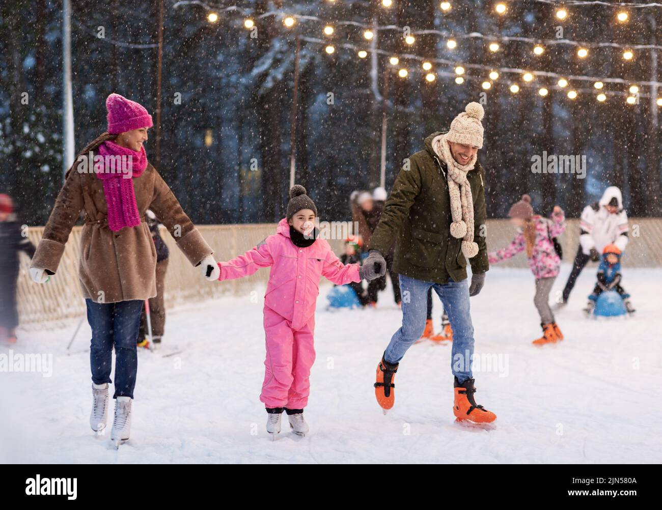 happy family at outdoor skating rink in winter Stock Photo - Alamy