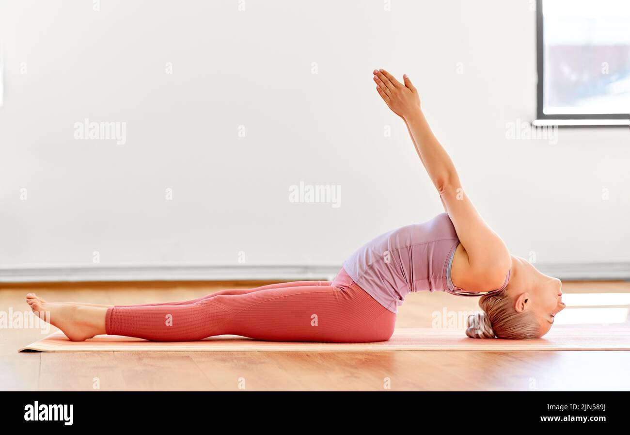 young woman doing fish pose at yoga studio Stock Photo - Alamy