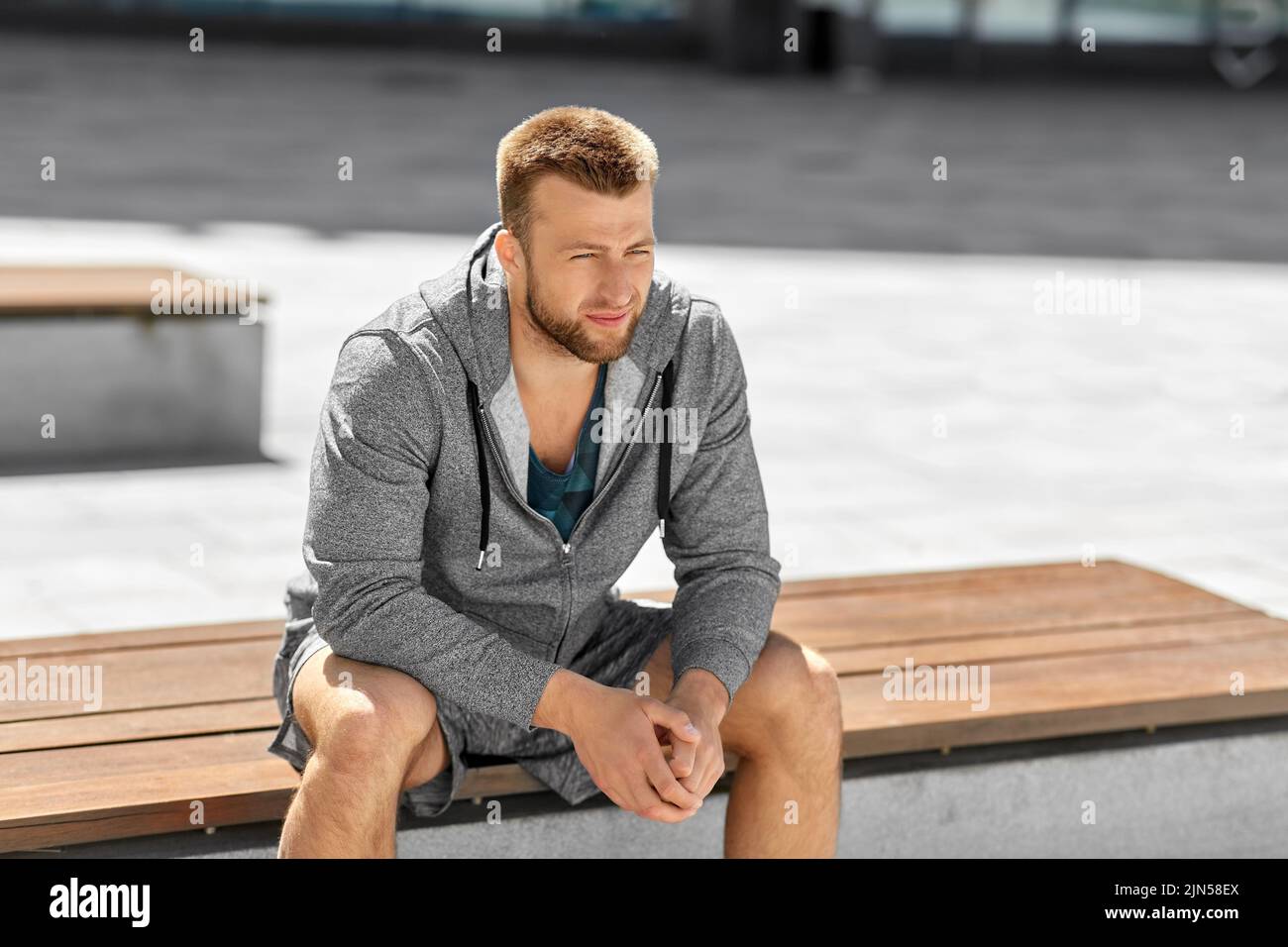 young man sitting on bench outdoors Stock Photo - Alamy
