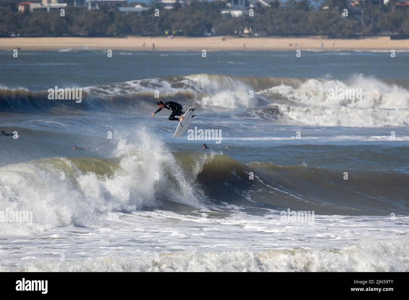 The surfer jumps above a wave. Alexandra Headland, Maroochydore ...