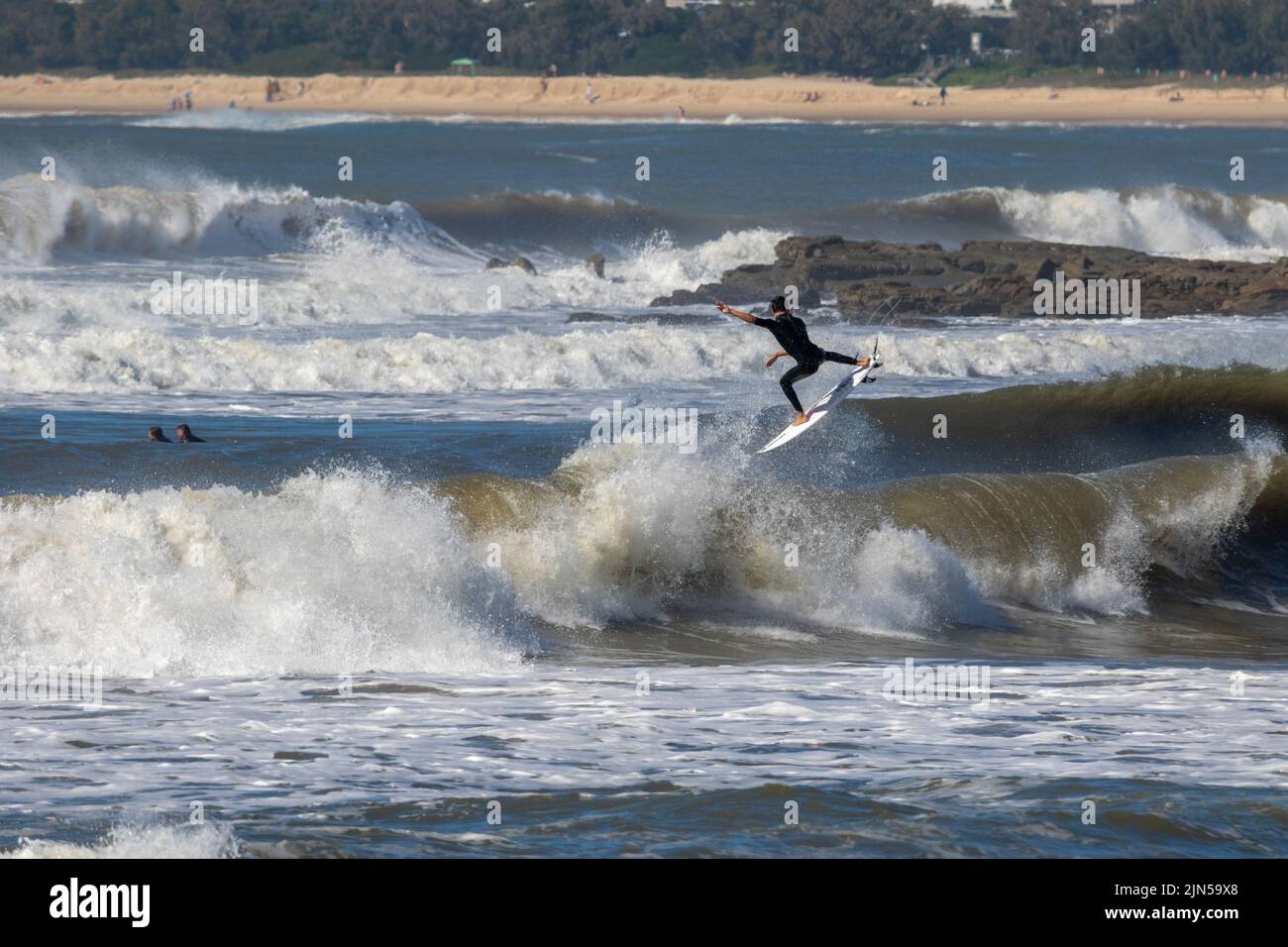 The surfer jumps above a wave. Alexandra Headland, Maroochydore ...