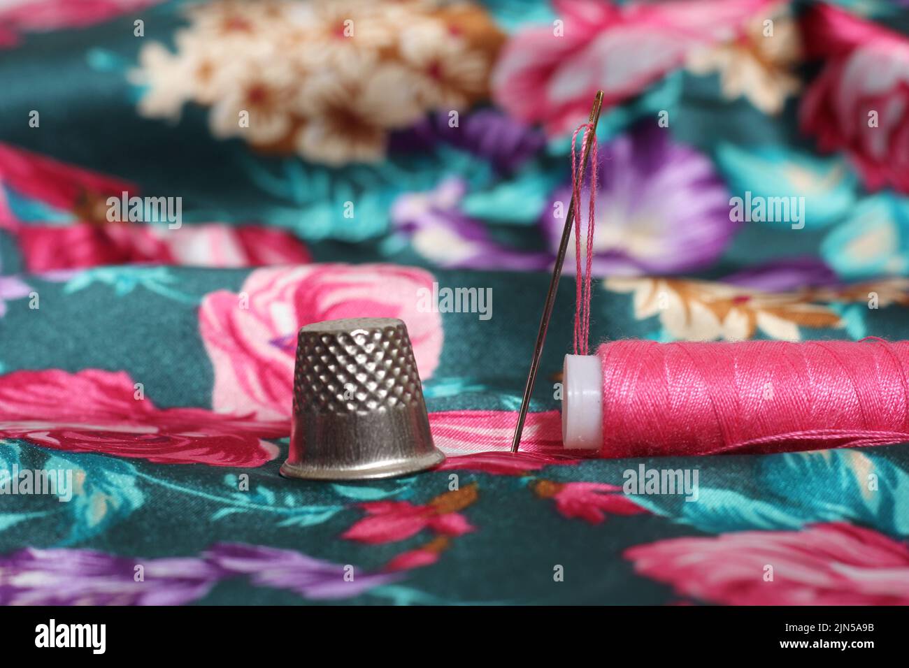 Thimble With Needle and Pink Thread on Vintage Floral Satin Fabric ...