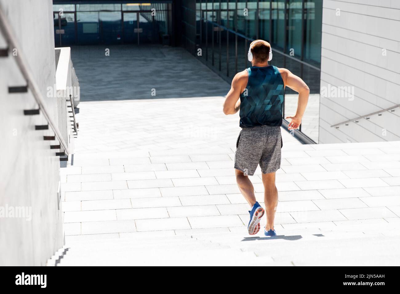 young man in headphones running downstairs Stock Photo - Alamy