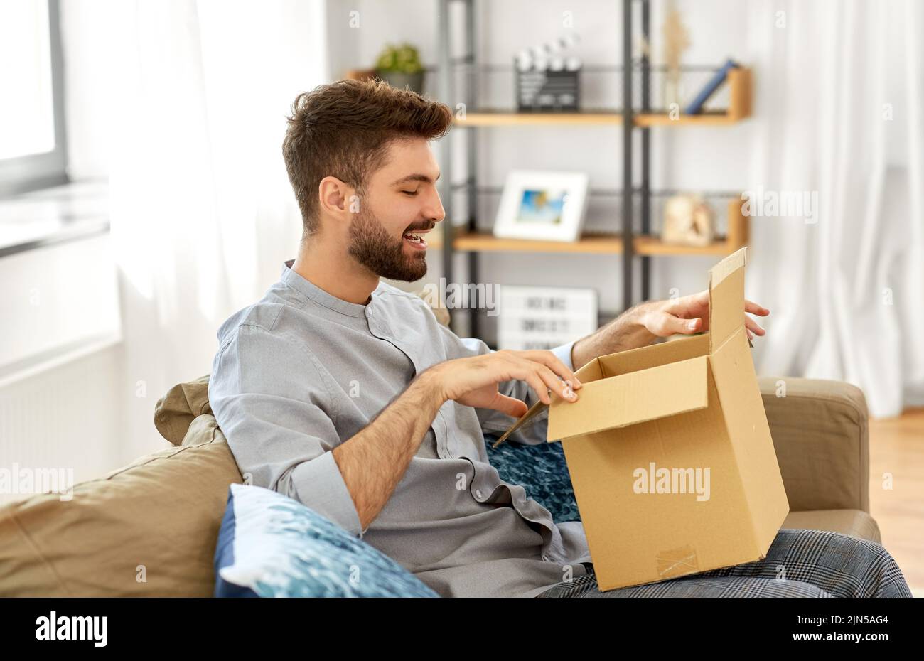 happy man opening parcel box at home Stock Photo - Alamy