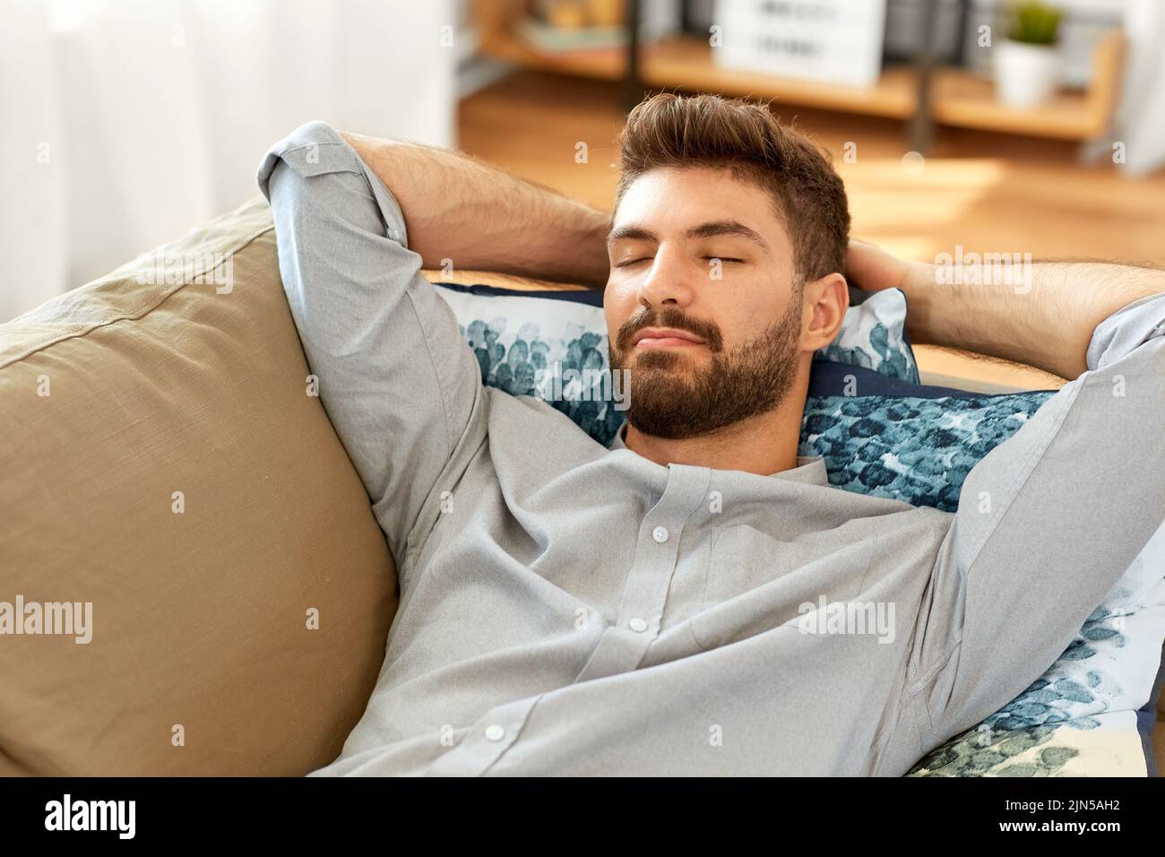 young man sleeping on sofa at home Stock Photo - Alamy