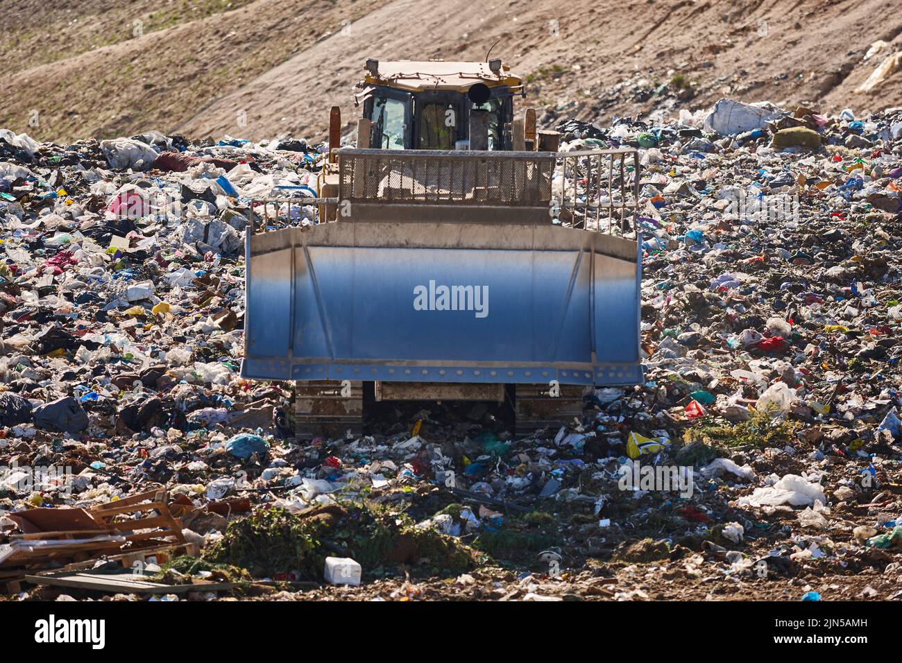 Heavy machinery shredding garbage in an open air landfill. Waste Stock ...