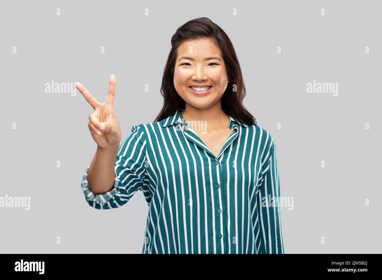 happy asian woman showing peace hand sign Stock Photo - Alamy