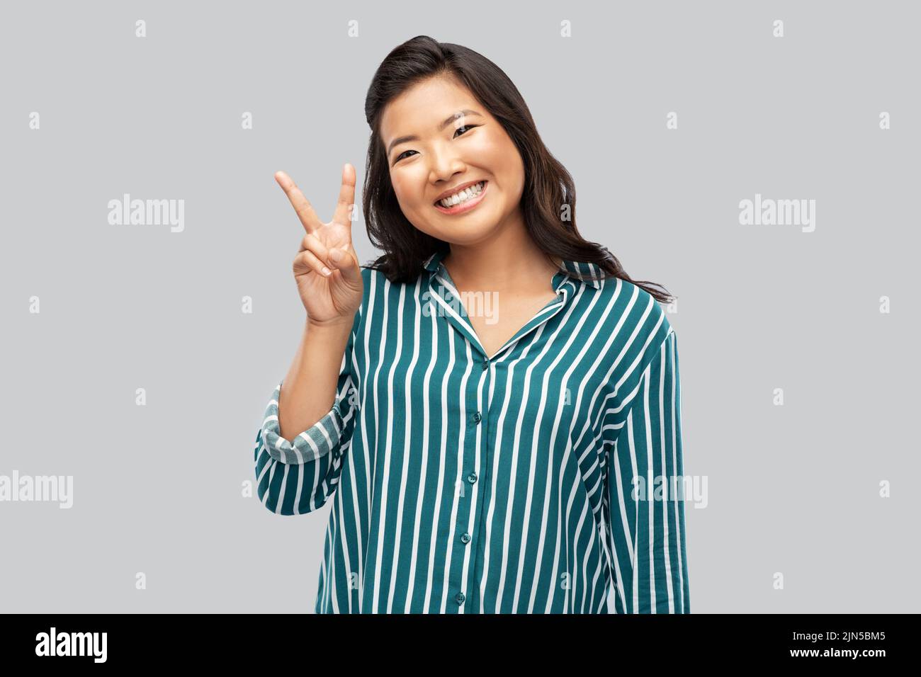 happy asian woman showing peace hand sign Stock Photo - Alamy