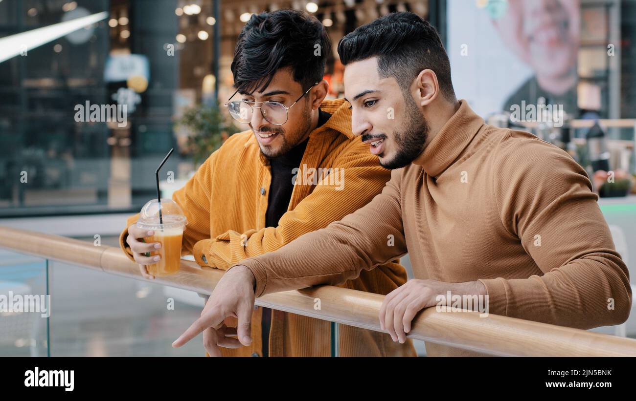 Two positive arab guys friends students stand in public place in ...