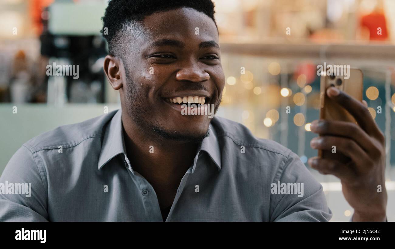 Happy confident young businessman holding phone looking at screen ...