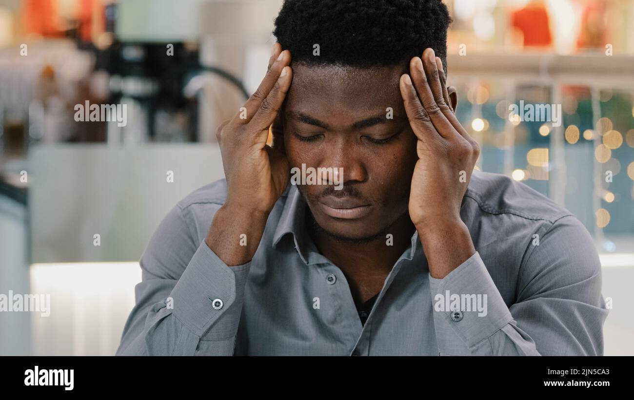 Portrait young sad tired young guy suffering from headache rubs temples ...