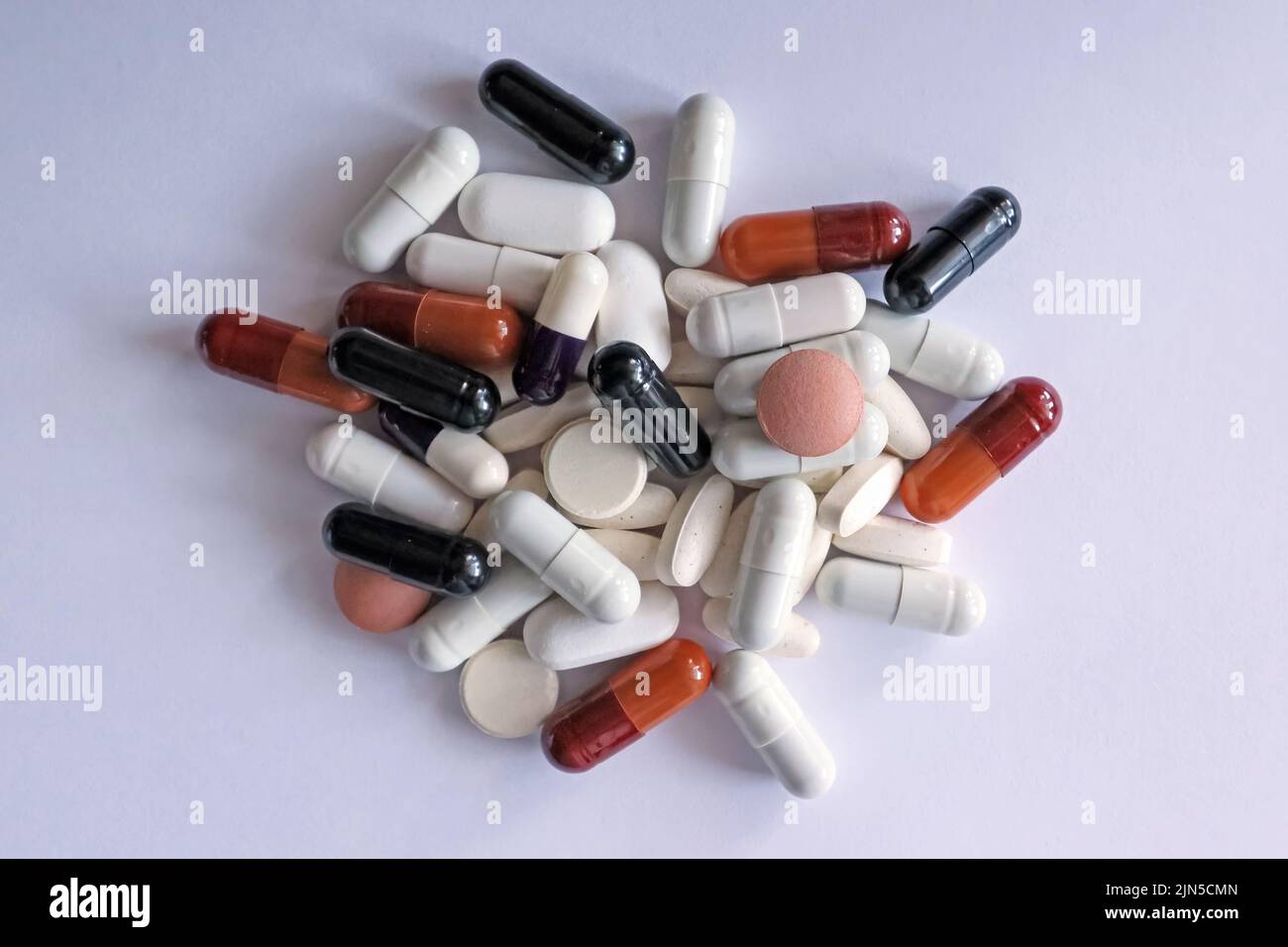 Various types of pills and tablets on a white sheet of paper Stock ...