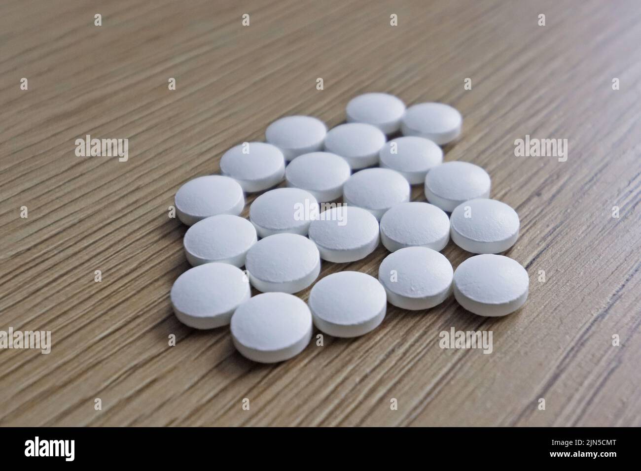 White tablets of a health herbal supplement on a wooden table Stock ...