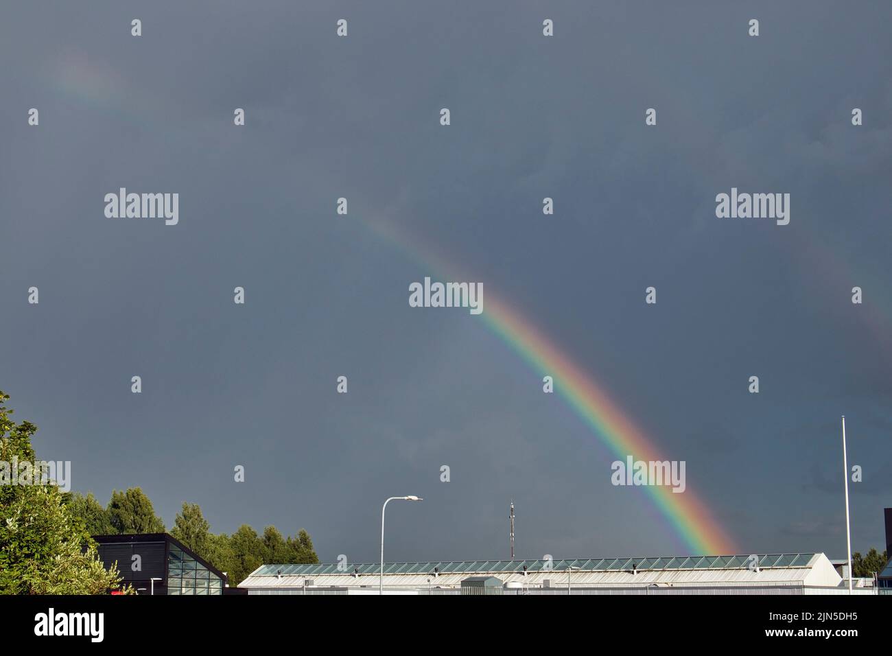 rainbow in a cloudy sky after heavy rain Stock Photo - Alamy