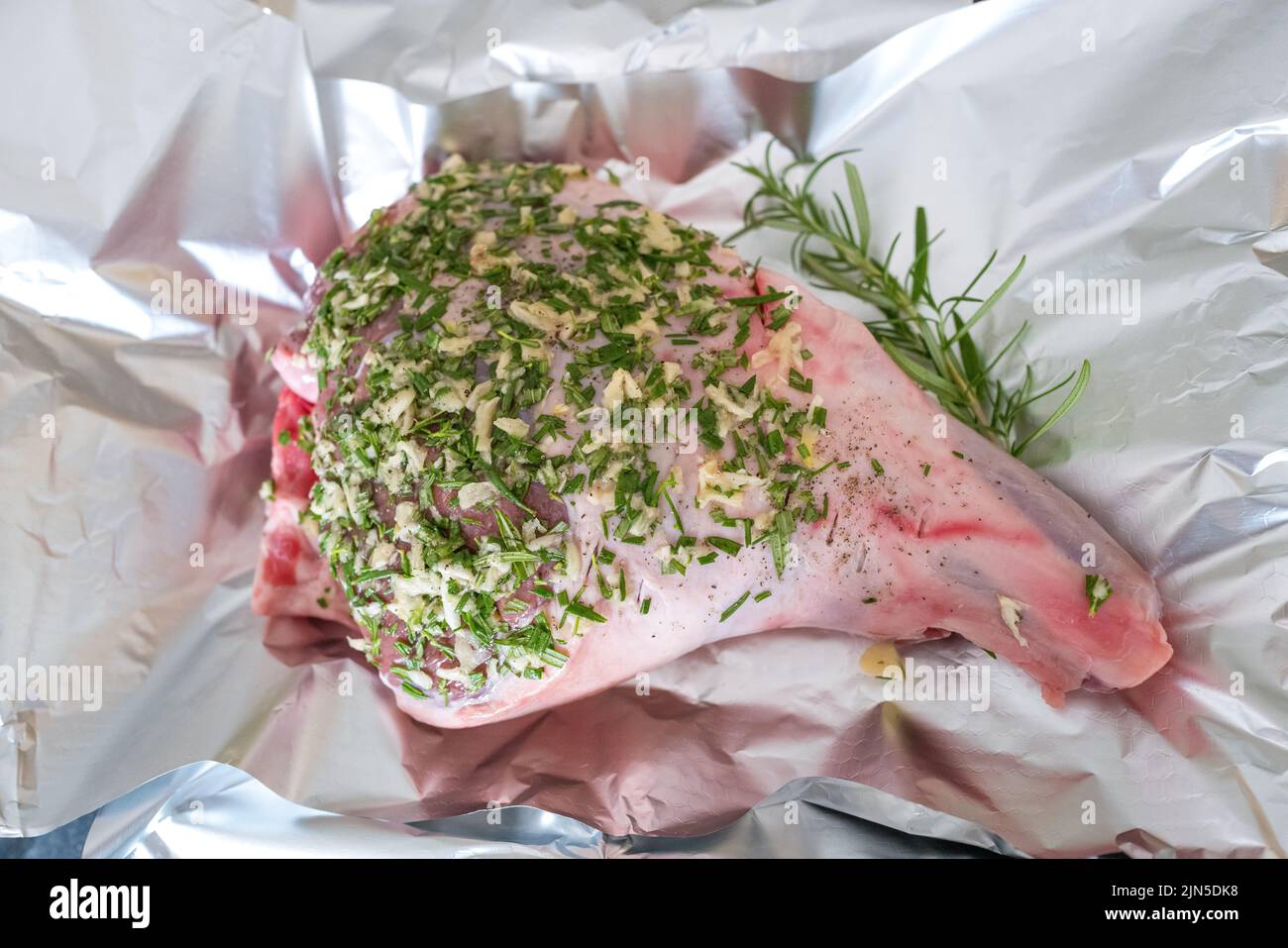 A leg joint of fresh English lamb ready for roasting with rosemary at ...