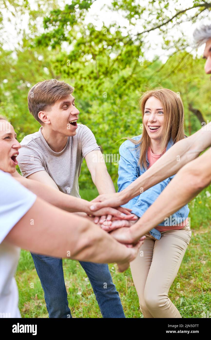 Young people celebrate success by stacking hands or doing a team ...