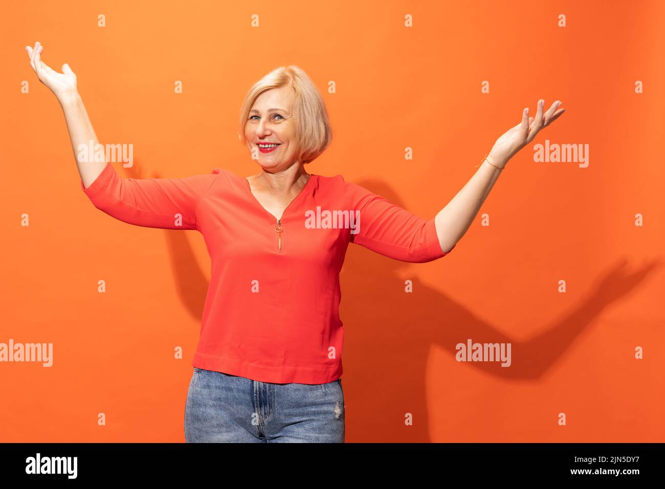 One excited beautiful middle age woman with blond hair posing isolated ...