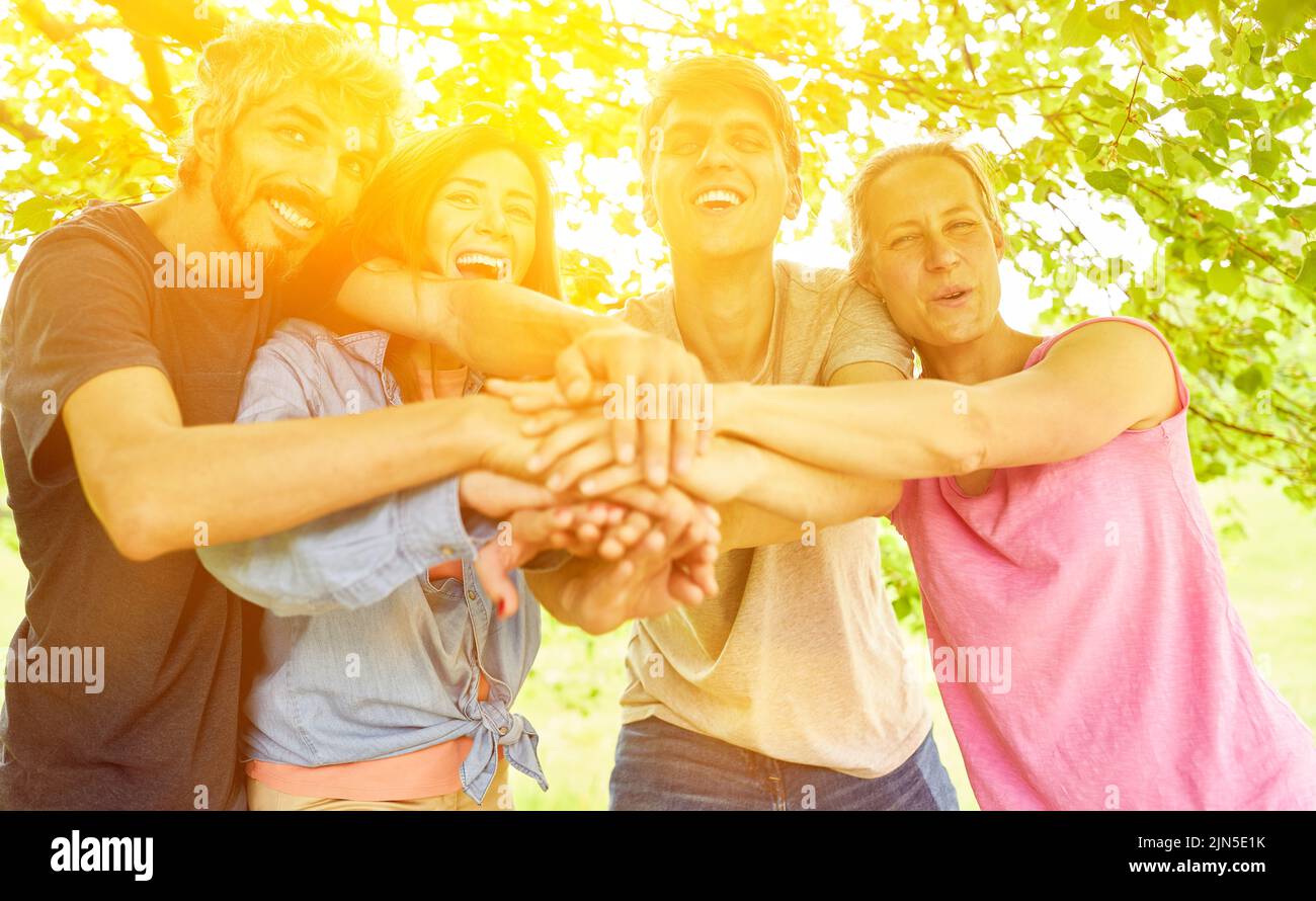 Group of friends stacking hands in nature as togetherness concept Stock ...
