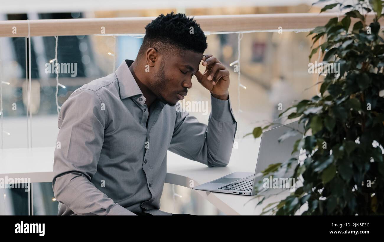 Shocked young businessman working on laptop feeling frustrated stressed ...