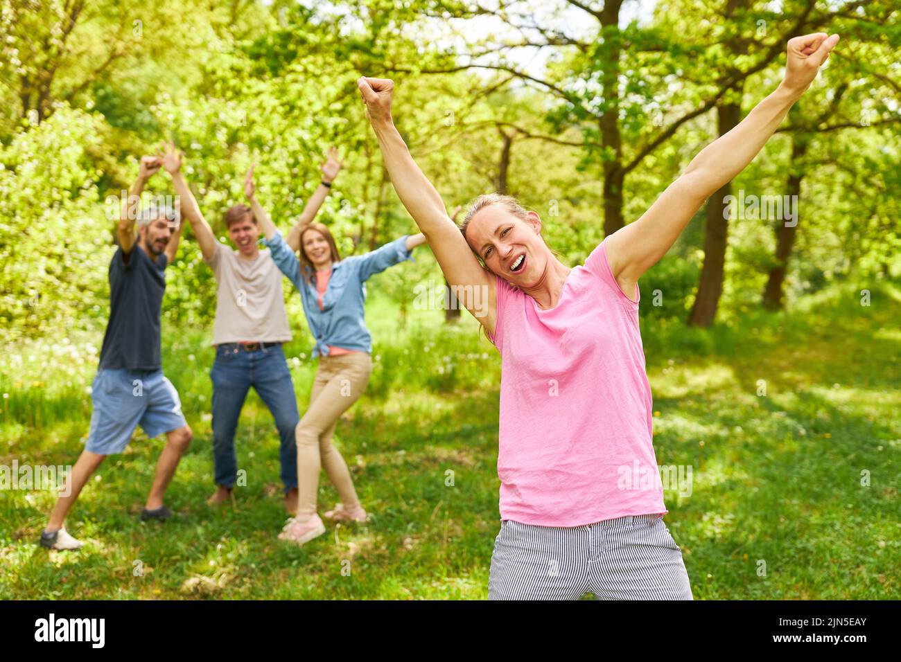 Sporty young woman cheering success in outdoor competition with team in ...
