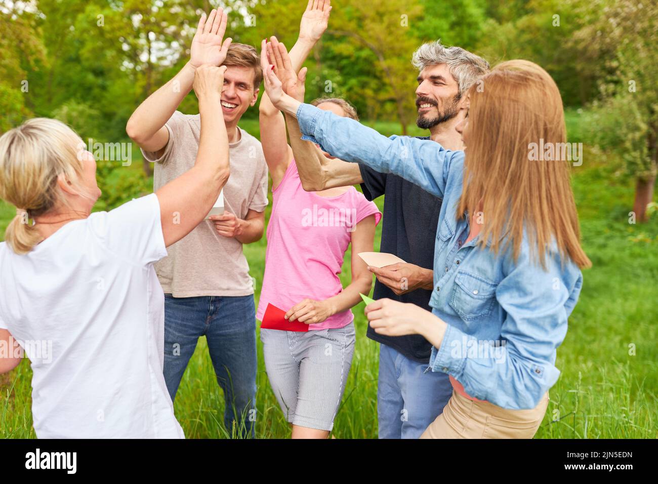 Group of young people giving high five for motivation in team building ...
