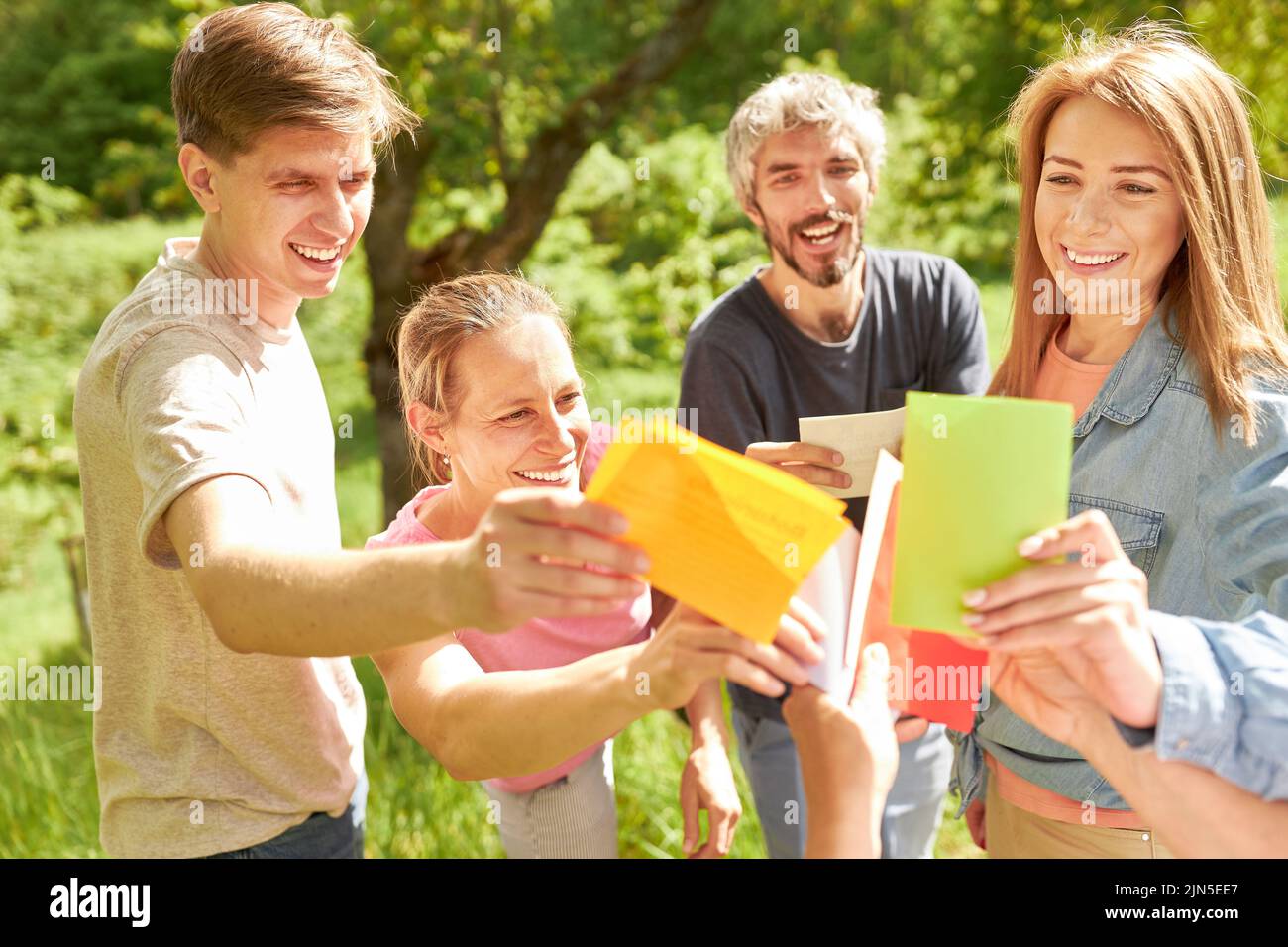 Young people drawing cards as a team training game for integration and ...