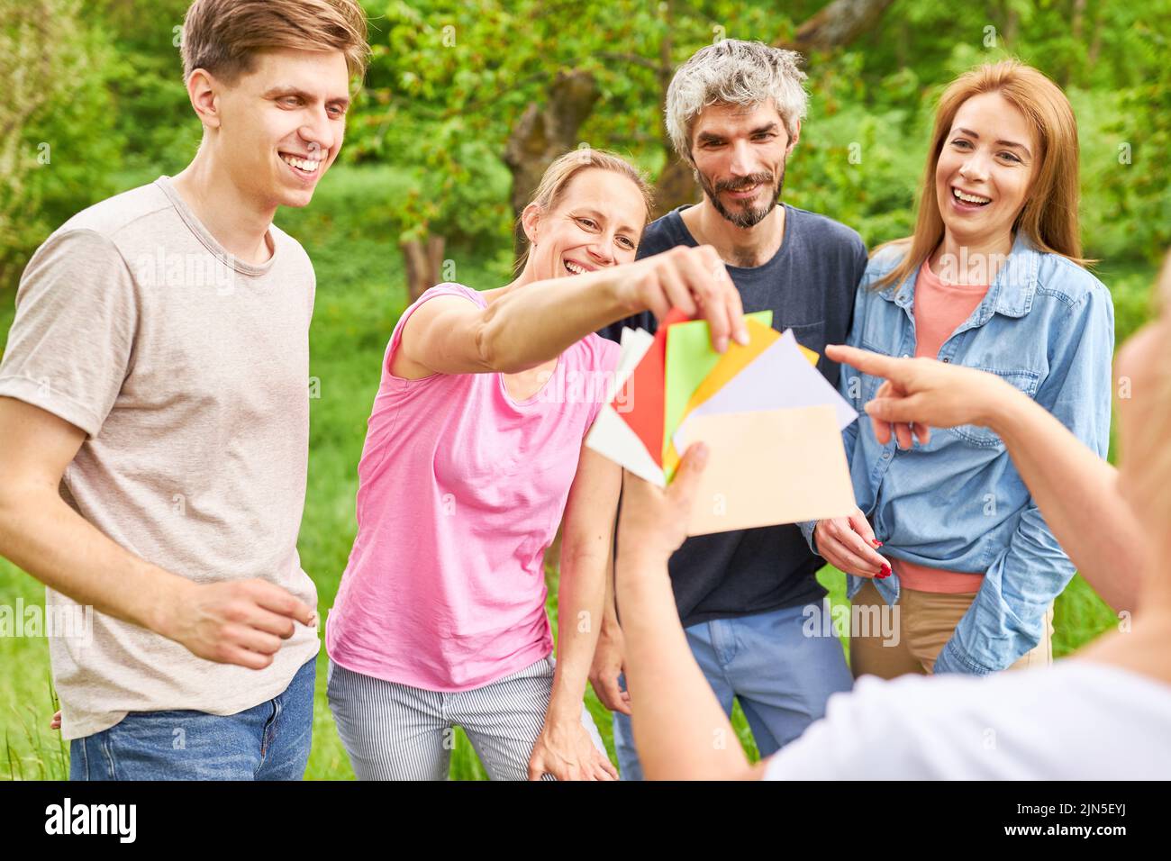 Team of young people draw colorful cards to get acquainted in team ...