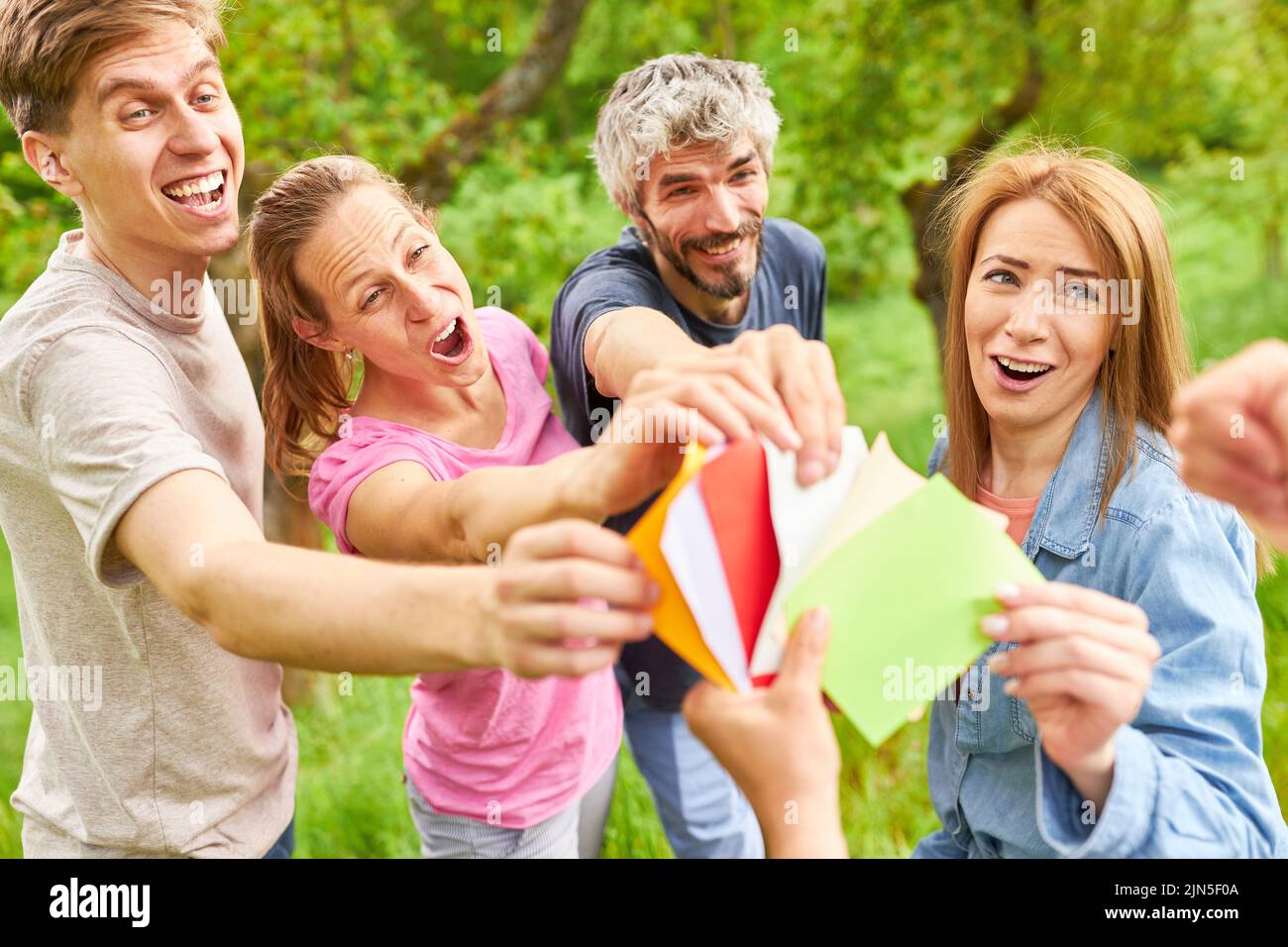 Cheerful group of young people have fun playing team building game and ...