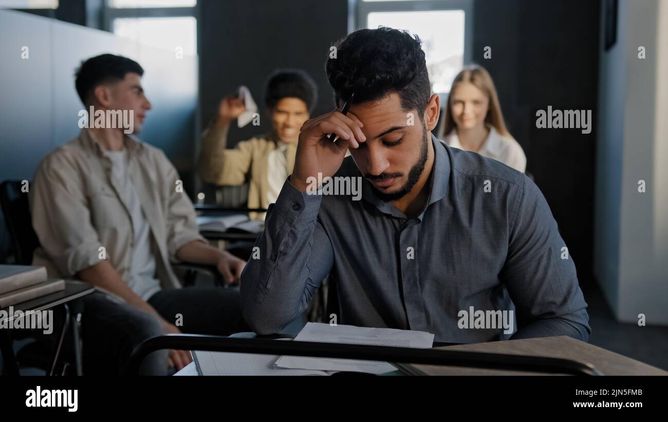 Frustrated oppressed indian student sitting in class lonely young guy ...