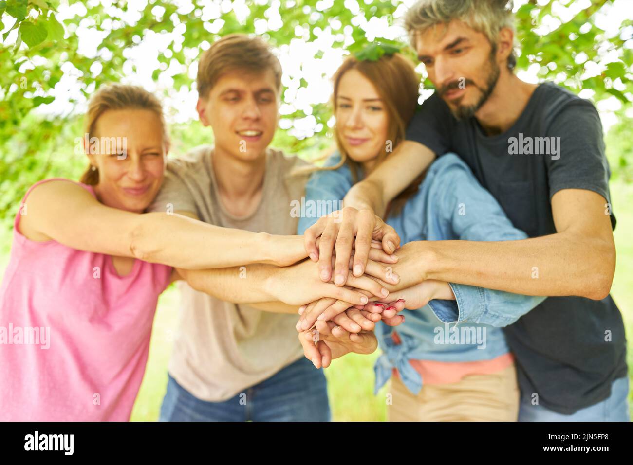 Young people stacking hands in the team building workshop for synergy ...