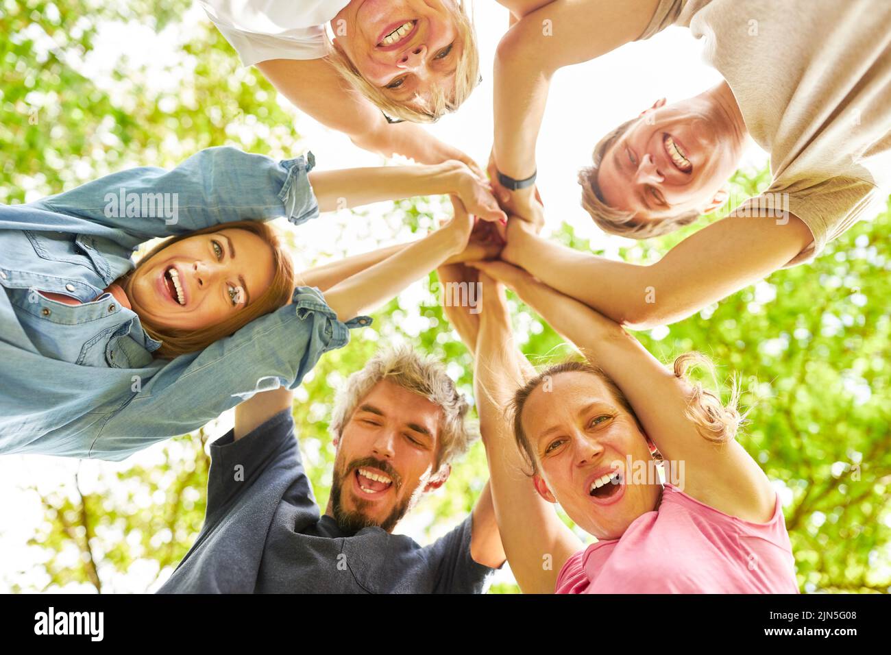 Powerful team have fun giving high five in circle for team spirit and ...