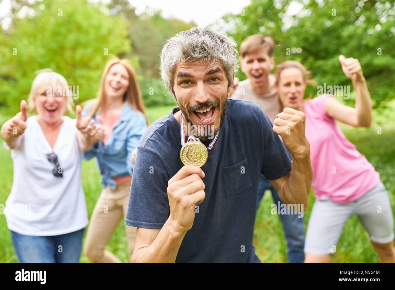 Cheering man with medal celebrates victory in competition together with ...