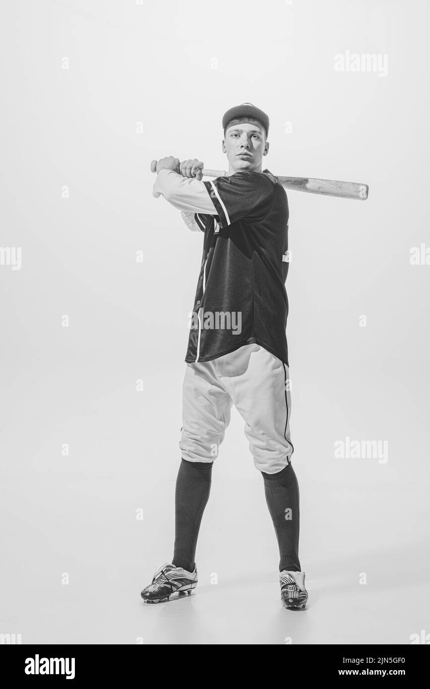 Full-length portrait of young man, student, baseball player in uniform ...